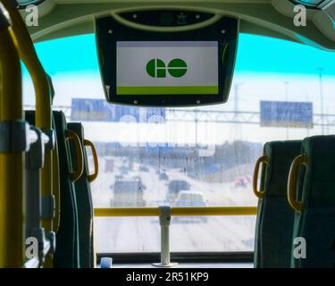 A GO Transit double decker bus travels along a busy street in downtown ...