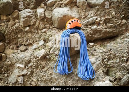 Blue climbing rope and helmet leaning against a rock face in Mallos de ...