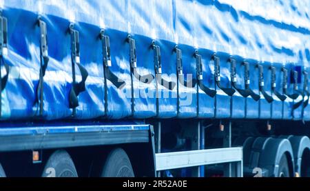 Straps on the side of an articulated lorry flap around in the wind ...