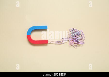 Magnet attracting paper clips on white background, top view Stock Photo ...