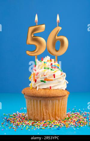 Number 56 blue celebration candle on white wooden background. Happy ...