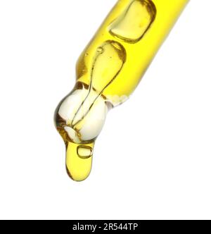 Dripping yellow facial serum from pipette on white background, closeup ...