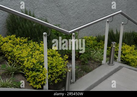 Outdoor staircase with metal handrails near beautiful plants Stock ...