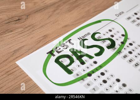 Answer sheet with word Pass on wooden table, closeup. Student passing exam Stock Photo - Alamy