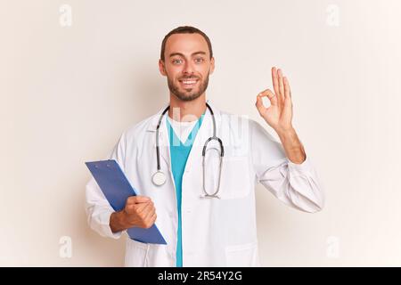 Attractive excited man wearing coat standing isolated over gray ...