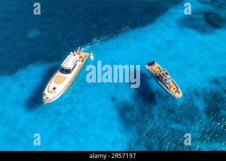 Aerial view of luxury boats on the Mediterranean Sea framed by blooming ...