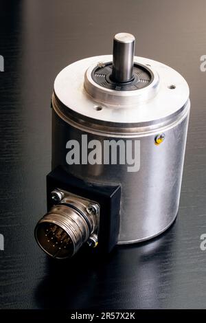 Metal encoder on a black wooden table, top view Stock Photo - Alamy