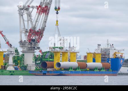 the Orion Offshore Heavy Lift crane moving wind turbine monopiles from ...