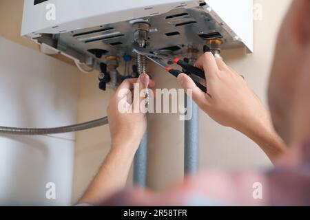 Man repairing gas boiler with waterpump plier, closeup Stock Photo - Alamy