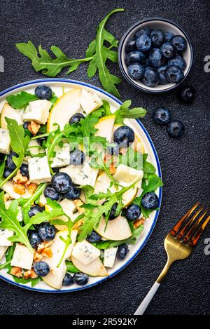 Delicious arugula salad with pears, blueberries, roquefort cheese and ...