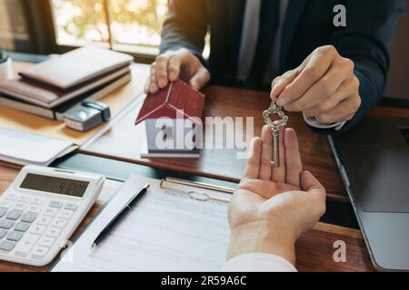 Salesman house brokers provide key to new homeowners in office Stock ...