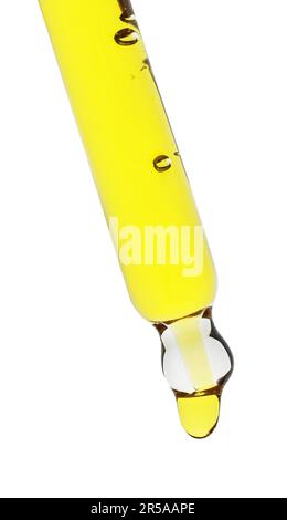 Dripping yellow facial serum from pipette on white background, closeup ...