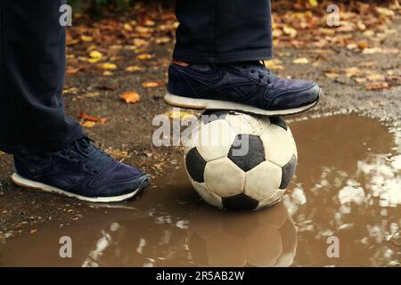 Man with soccer ball in muddy puddle outdoors, closeup Stock Photo - Alamy