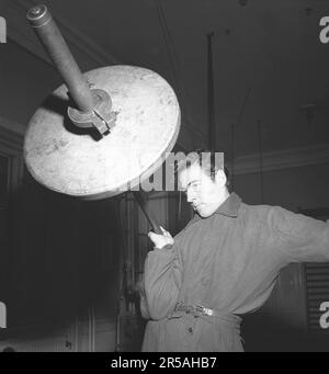 Strength training in the 1940s. A young man works out his muscles with ...
