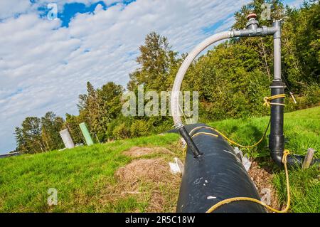 A vertical landfill methane gas wellhead and valve at an active ...