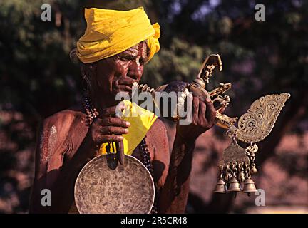 An Indian sadhu (holy man) blowing a conch shell, a symbol for god ...