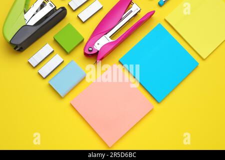 Flat lay composition with new staplers on yellow background Stock Photo ...