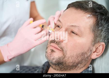 Unshaven male gets subcutaneous injections of the frontal zone Stock ...