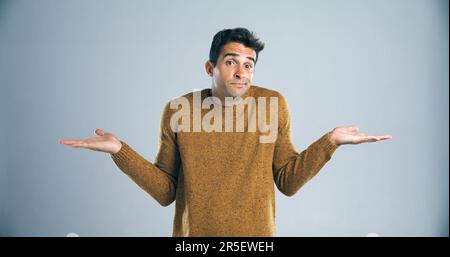 Feeling unsure. Studio shot of a handsome young man looking uncertain ...