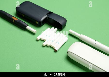 Different electronic cigars with sticks on white and black background ...