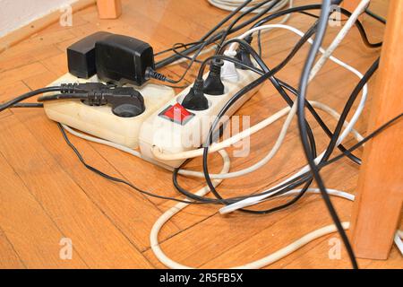 Tangled cables in the extension cord. Messy cables. Cables tangled on ...