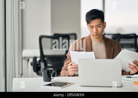Asian businessman reading financial document in the office Stock Photo ...
