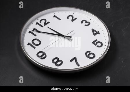 Clock showing five minutes until midnight on white background, closeup ...