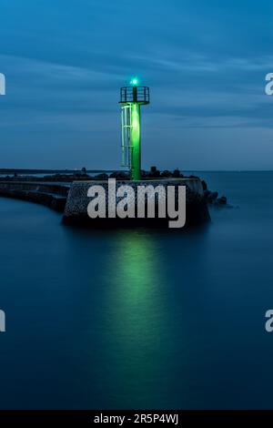 Stone pier in Darłowo in the evening. Lights on the beach. Traffic ...
