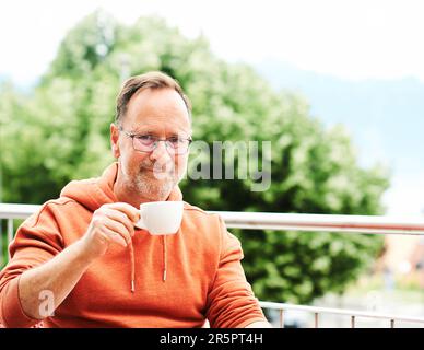 Middle age handsome man at the terrace of his house relaxing lying on a ...