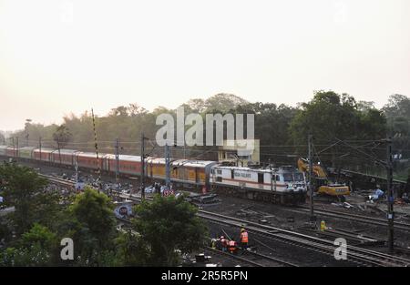Balasore. 5th June, 2023. A passenger train passes by the site of a ...