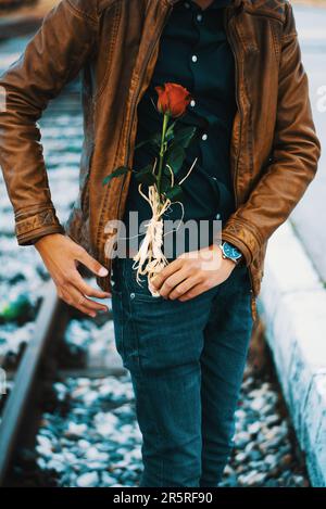 A young man stands leaning on a table in the office Stock Photo - Alamy