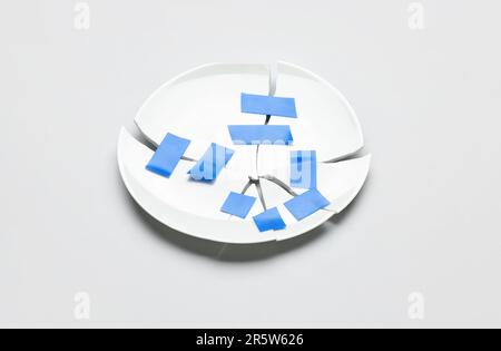 Broken plate with adhesive tape on light background Stock Photo - Alamy