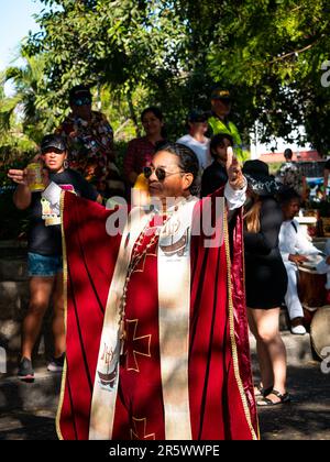 Bald Latin male in a red coat talking on his phone while walking in a ...