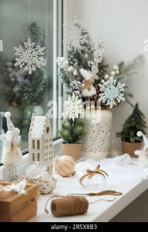 Beautiful window sill decorated for Christmas with small houses and fir ...
