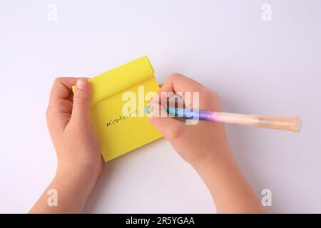Child erasing word Mistake written with erasable pen on sticky note ...