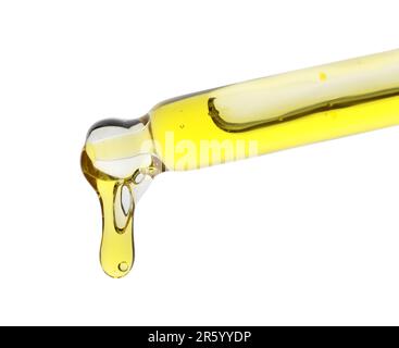 Dripping yellow facial serum from pipette on white background, closeup ...