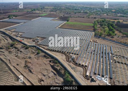 An aerial view of a large-scale solar farm with an array of black solar ...