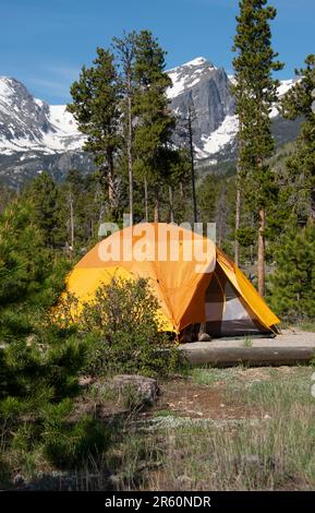 Tenting in orange tent camping with Hallet Peak and snow covered Rocky ...
