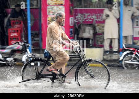 Lahore, Pakistan. 6th June, 2023. Vehicles run on a road amid heavy ...