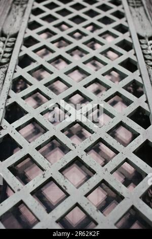 A decorative copper metal fence with a square grid pattern in a black ...