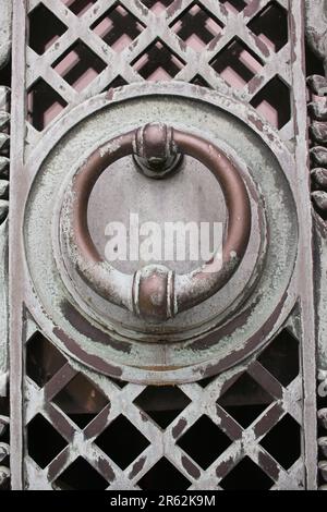 A round door handle protecting a traditional medieval gate in a black ...