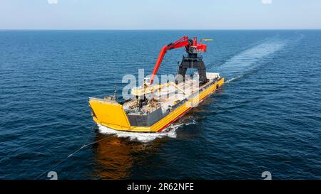 Barge loaded with tracked harbour material handling cranes, being ...