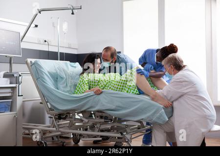 Pregnant woman pushing and screaming during childbirth, receiving ...