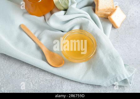 Bowl of honey with flowers of acacia and crackers on blue background ...