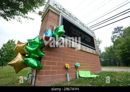 A sign and flowers were placed at the entrance sign for Huguenot High ...