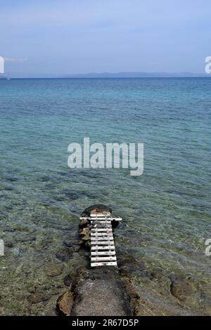Small old wooden jetty leading the eye to the horizon, Agistri island ...