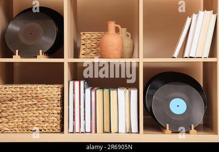 Wooden shelving unit with vinyl records near beige wall indoors Stock ...