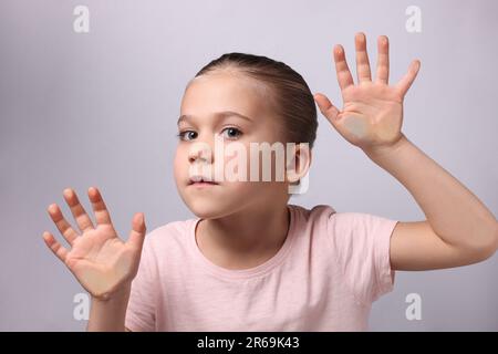 Cute little girl stuck to transparent screen Stock Photo - Alamy