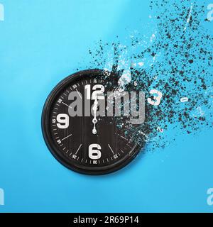 Flow of time. Analog clock dissolving on yellow background, space for ...