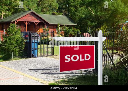 Red Sold sign near beautiful house outdoors Stock Photo - Alamy